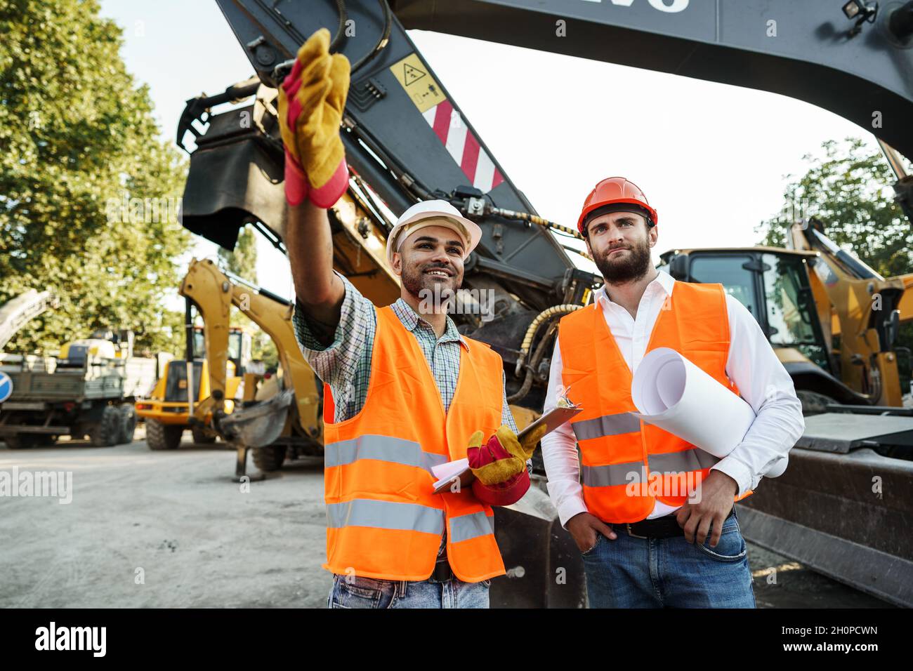 Two men engineers discussing their work standing against construction ...