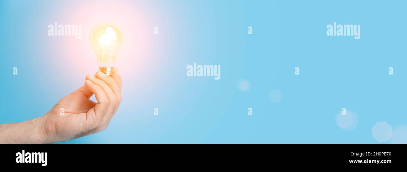 Knowledge and idea concept. Light bulb with light in hand on a blank ...