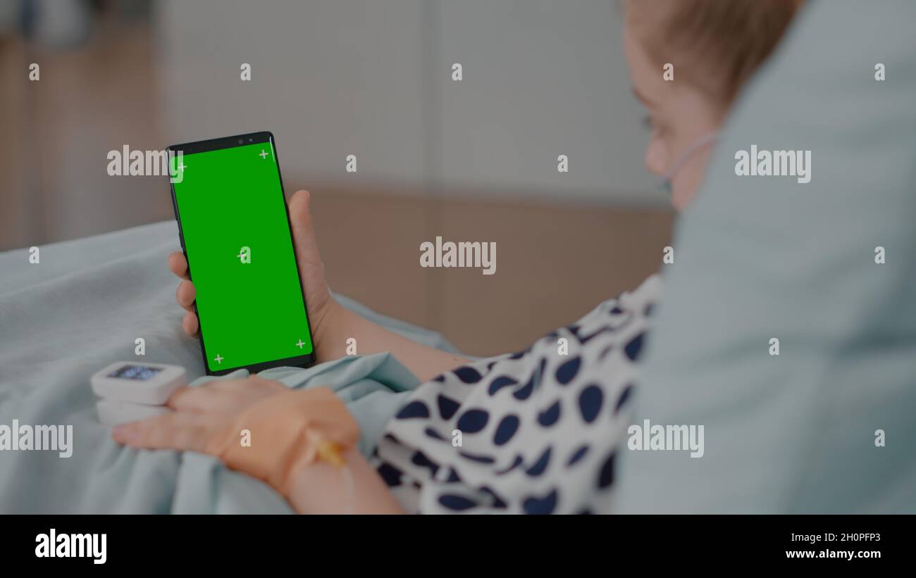 Sick girl resting in bed with medical oximeter on finger looking at ...