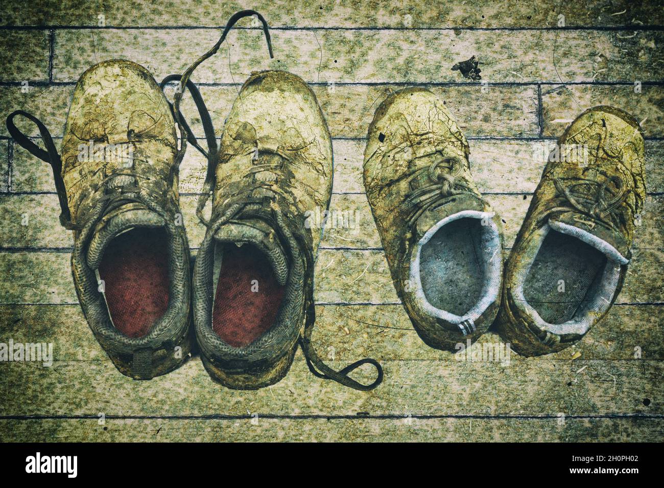 A p[air of muddy trainer shoes after a muddy Winter walk on the floor ...