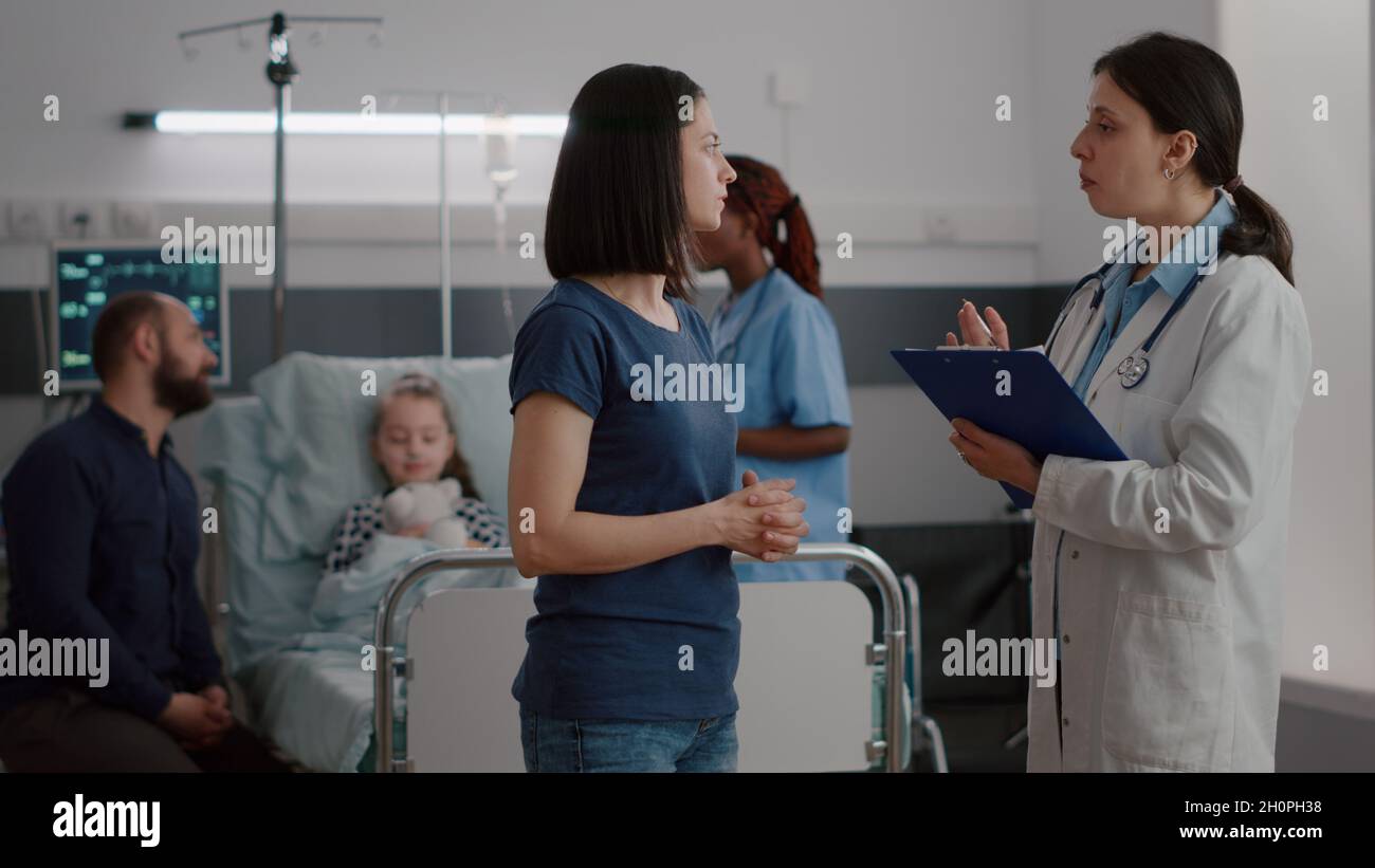 Pediatrician woman doctor explaining recovery treatment to worried ...