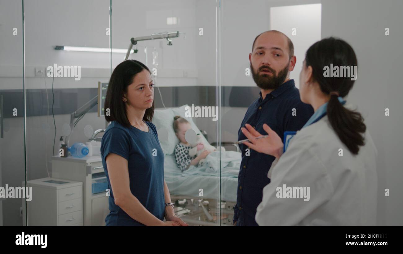 Worried parents discussing sickness recovery treatment with ...