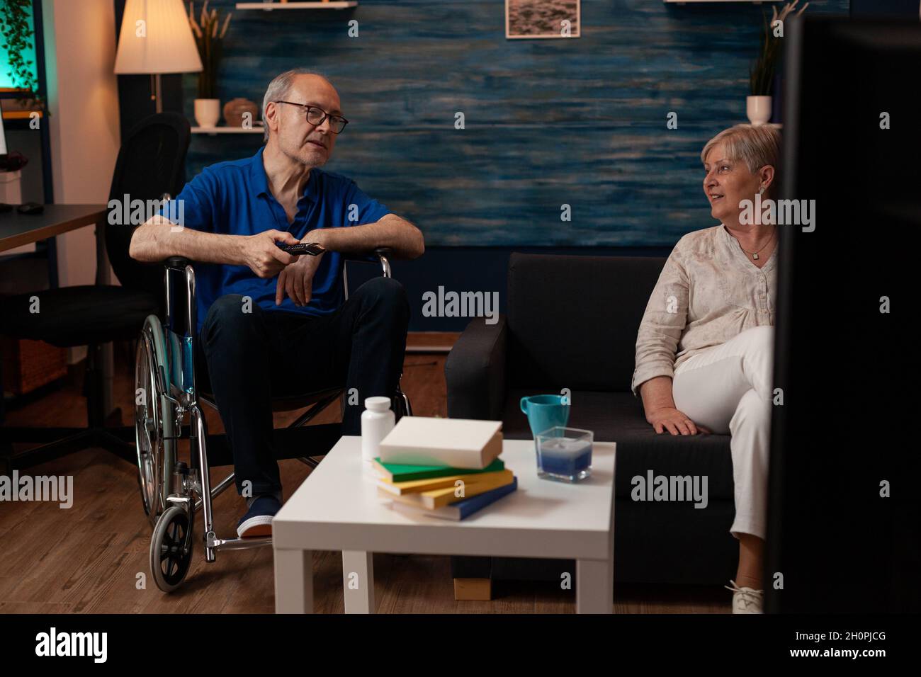 Aged married couple relaxing in living room watching TV at home ...
