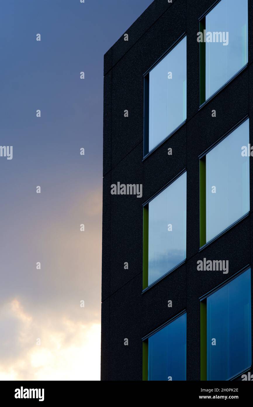 Side view of a modern building facade with big windows in the evening ...