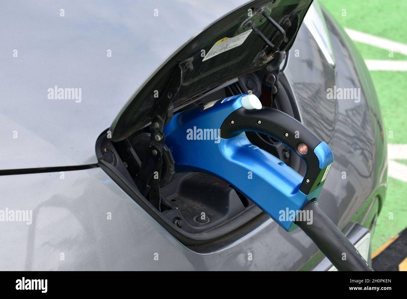 close up of an electric car charging handle inserted into car energy ...
