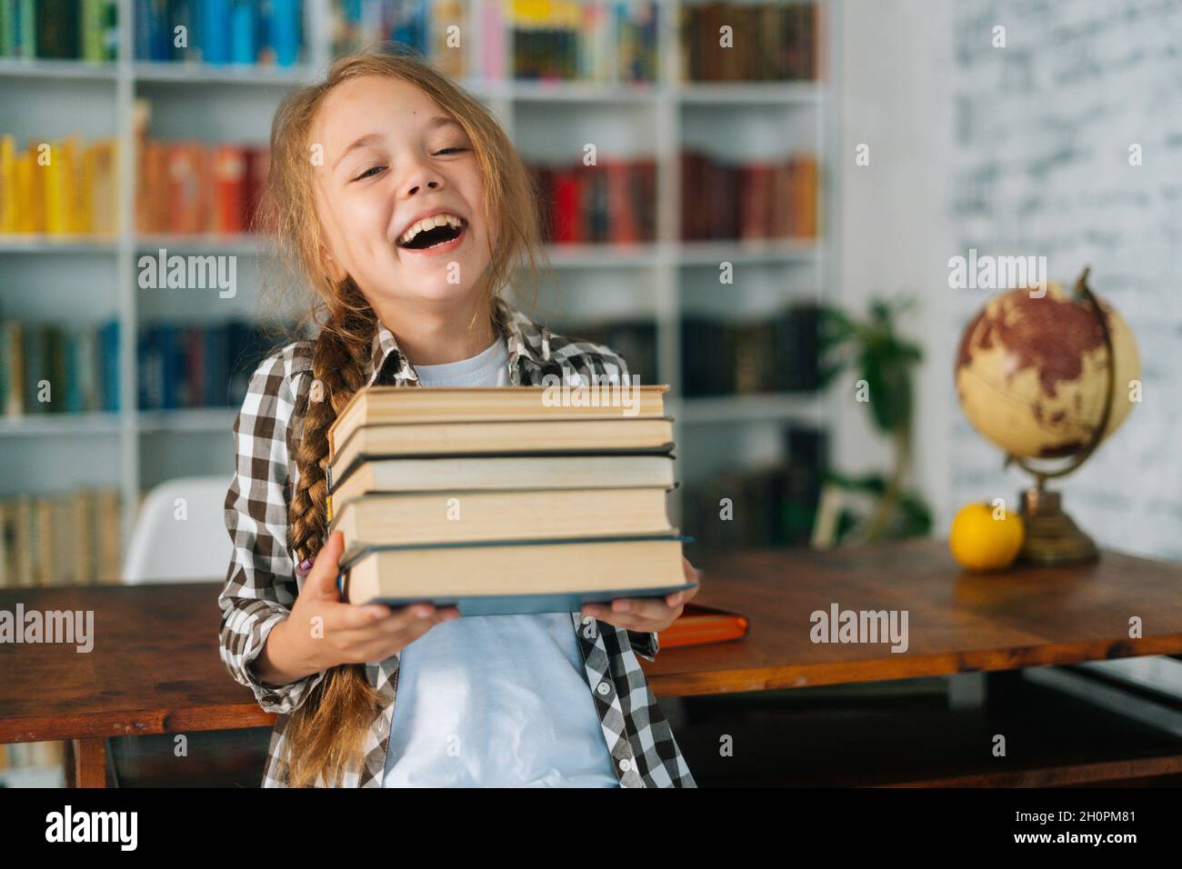 Medium shot portrait of laughing elementary child school girl holding ...