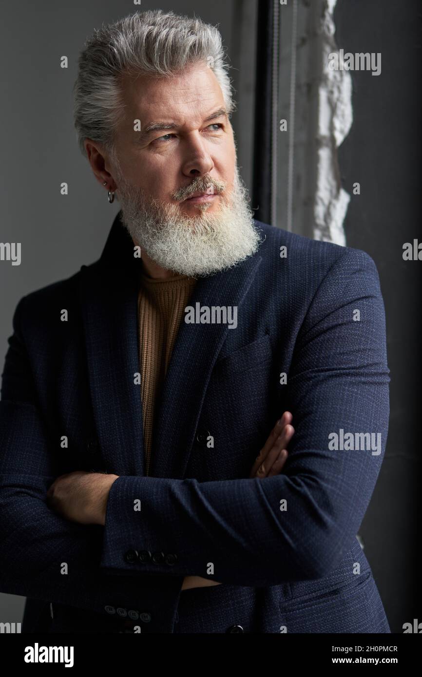 Portrait of serious gray haired middle aged man in business casual wear ...