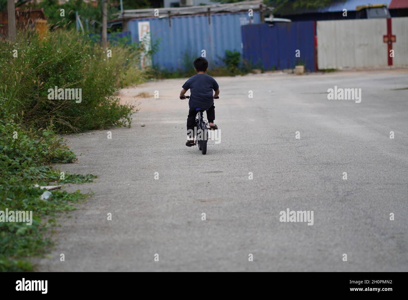 A kid riding his bicycle in the evening. Aktiviti basikal Malaysia ...