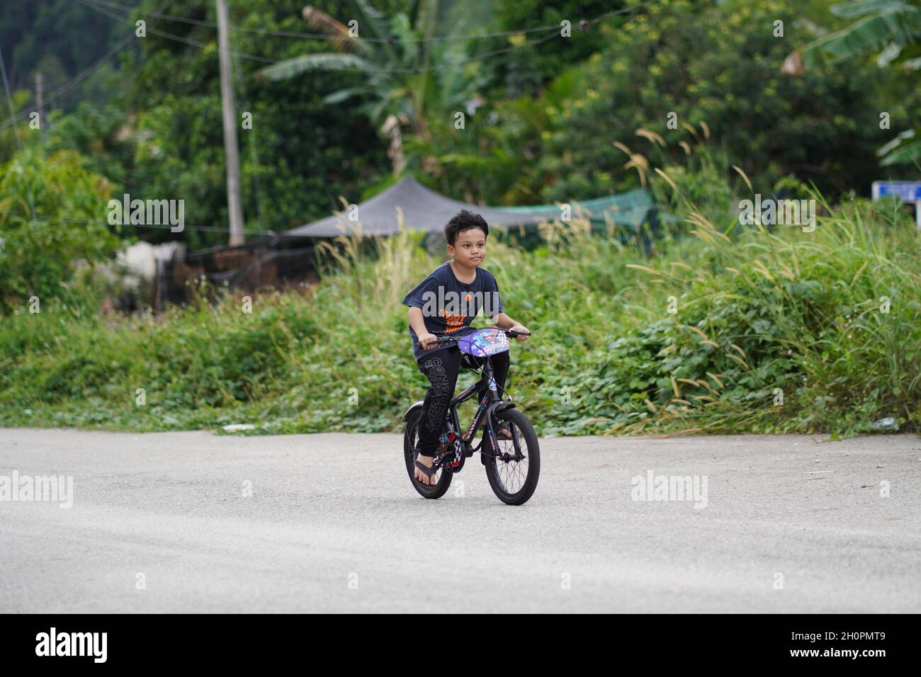 A kid riding his bicycle in the evening. Aktiviti basikal Malaysia ...