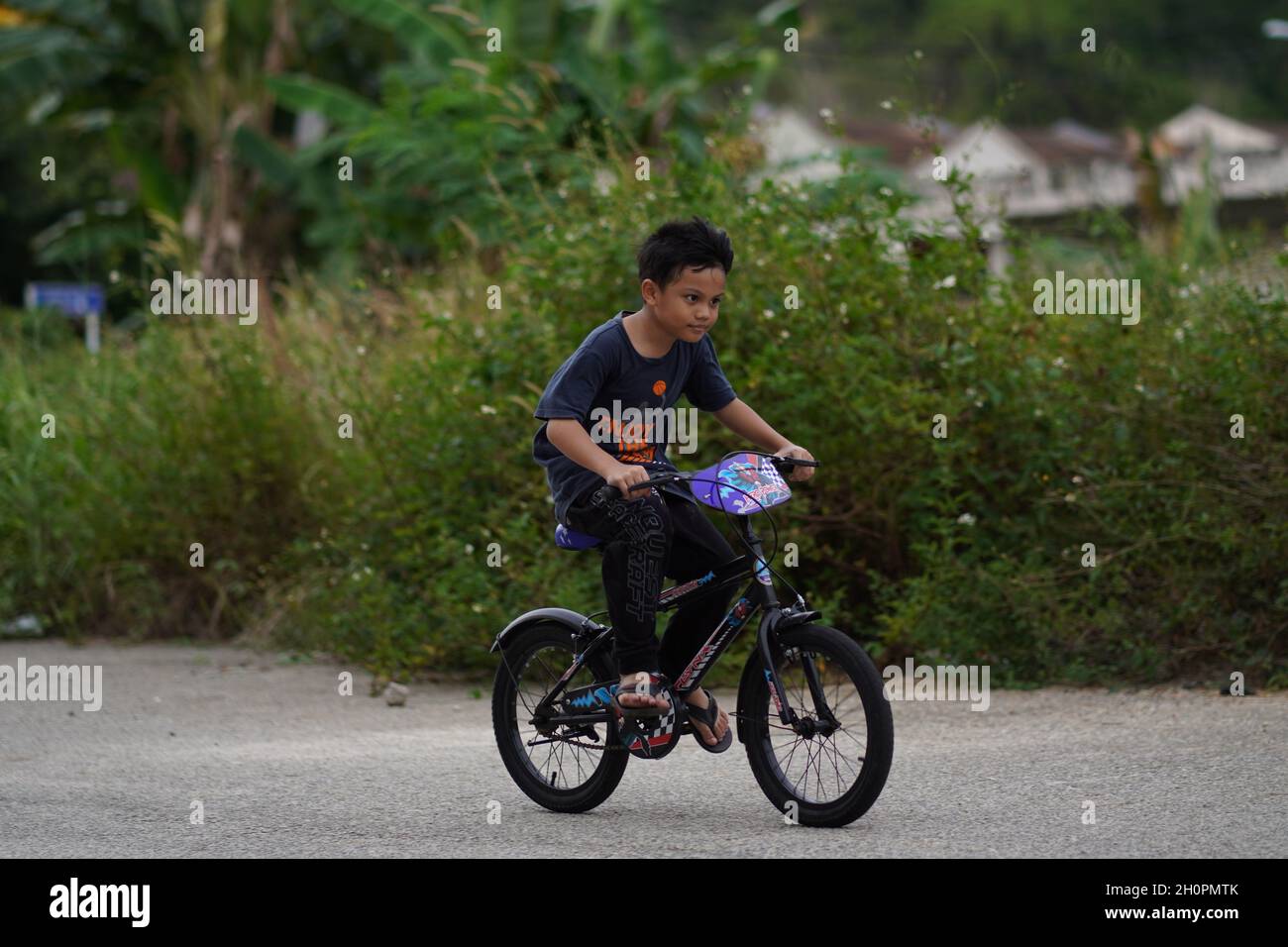 A kid riding his bicycle in the evening. Aktiviti basikal Malaysia ...
