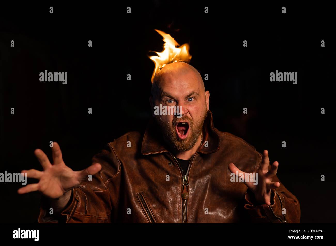 Bald man in a leather jacket with a burning head on a dark background ...