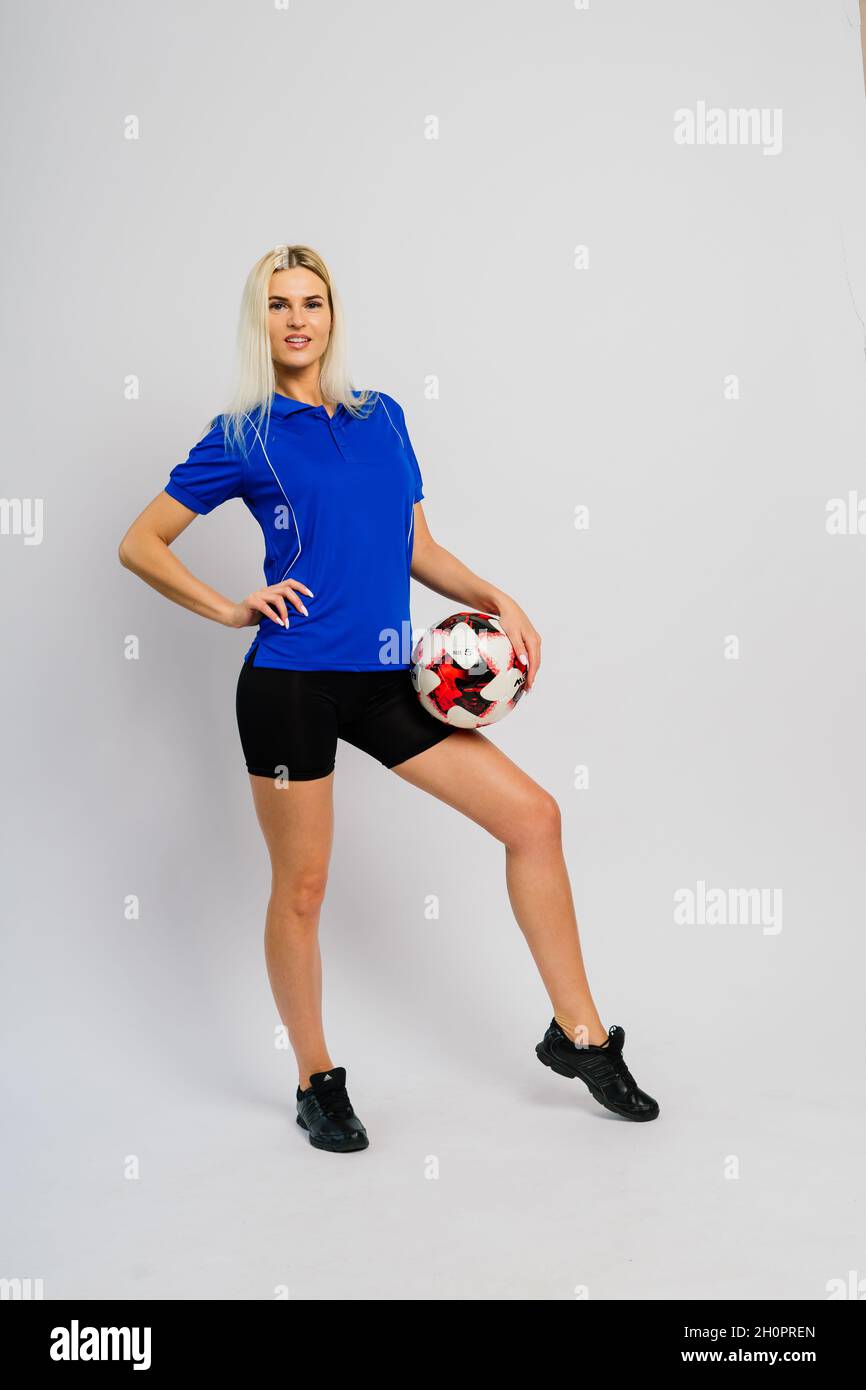 Female football fan in sport style with soccer ball. Studio shot ...