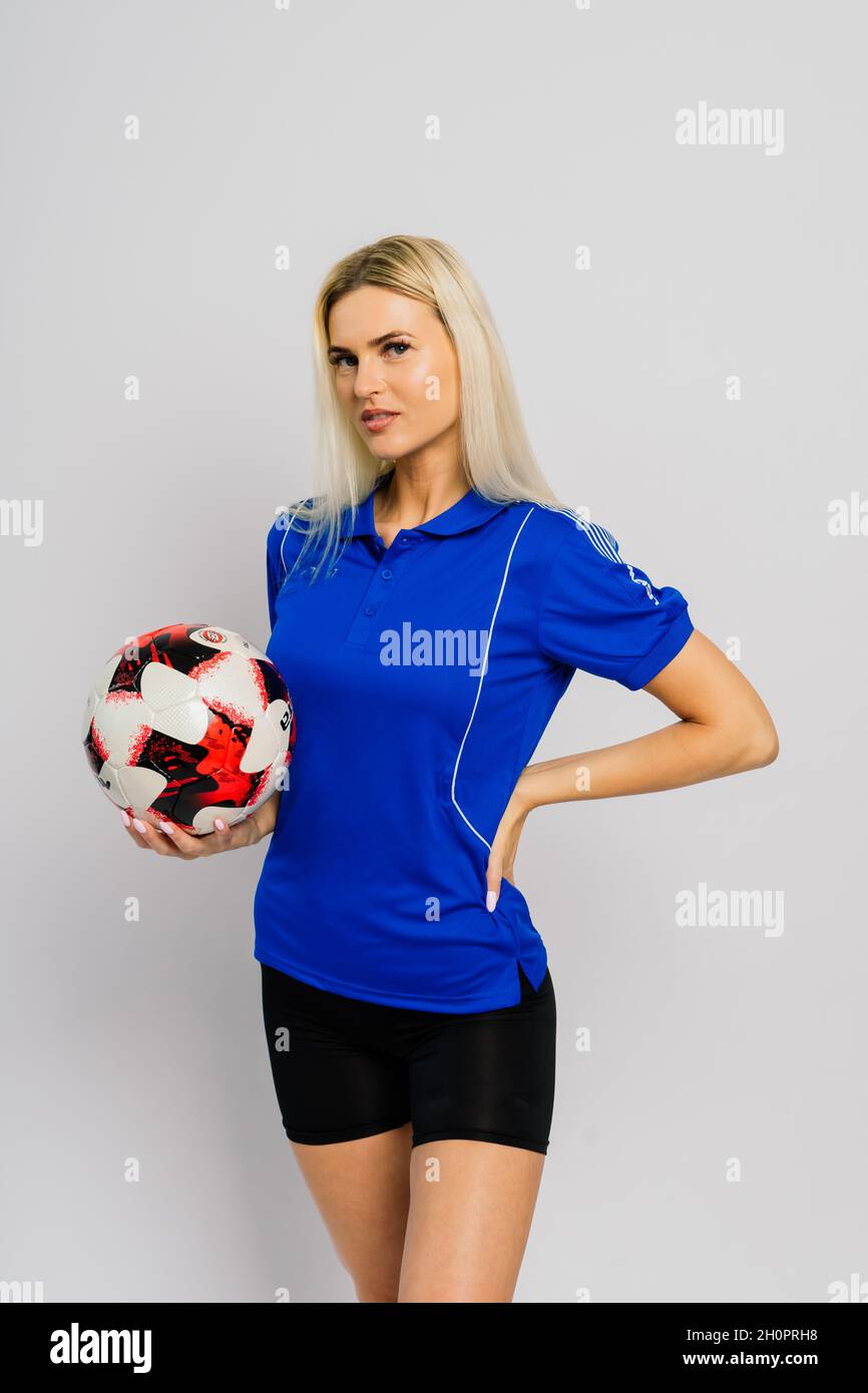 Female football fan in sport style with soccer ball. Studio shot ...