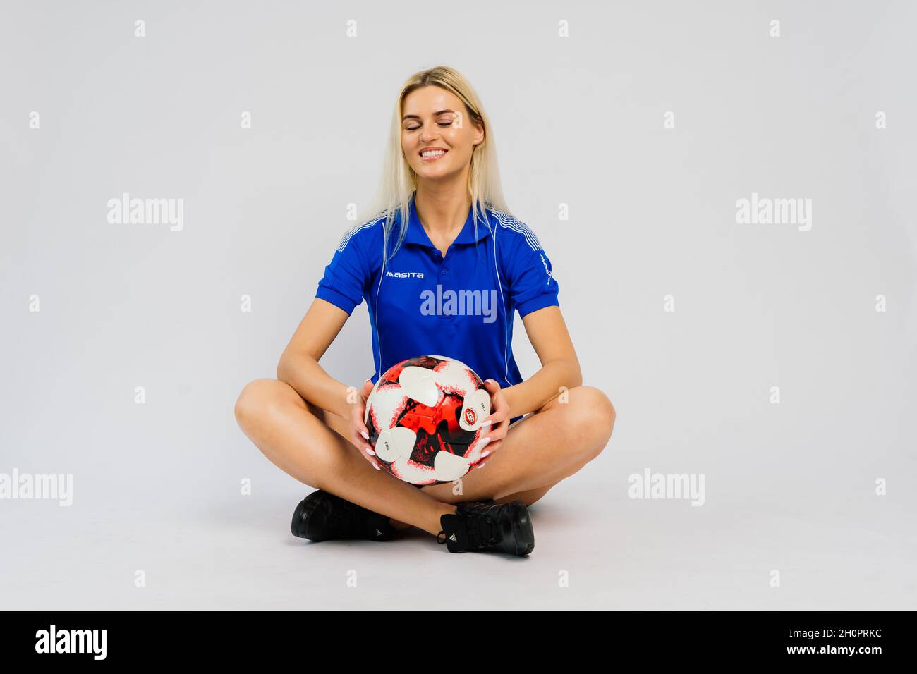 Female football fan in sport style with soccer ball. Studio shot ...
