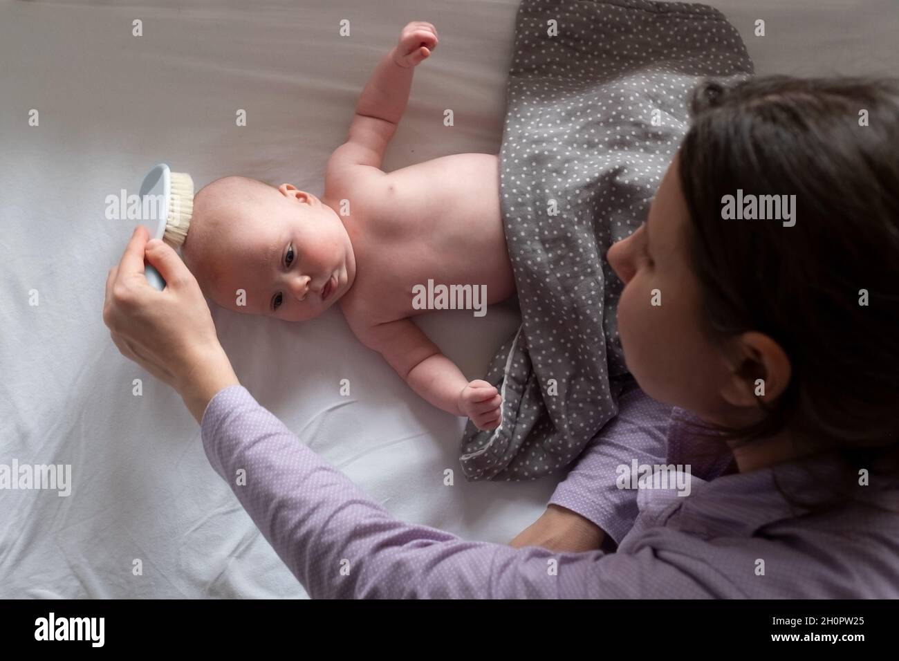 Hairbrush and baby care. Mother combing newborn hair Stock Photo - Alamy