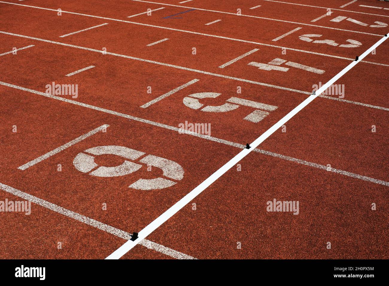 Shot of a brown running track with white numbers indicating finishing ...