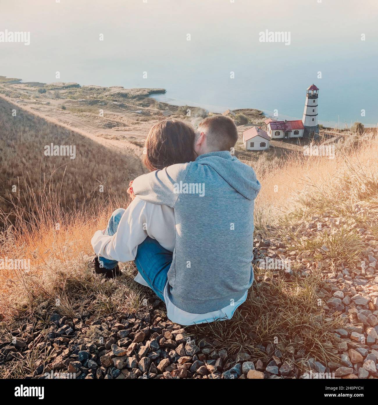 Romantic couple dressed in cozy sweaters together near the lighthouse ...
