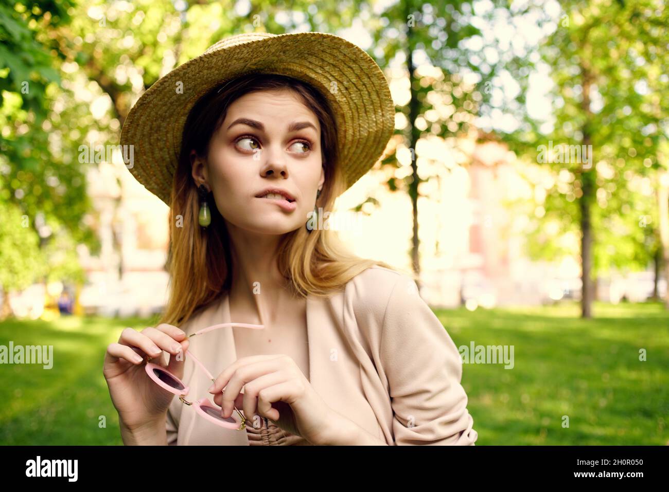 woman sunglasses and a hat in the park green grass Stock Photo - Alamy