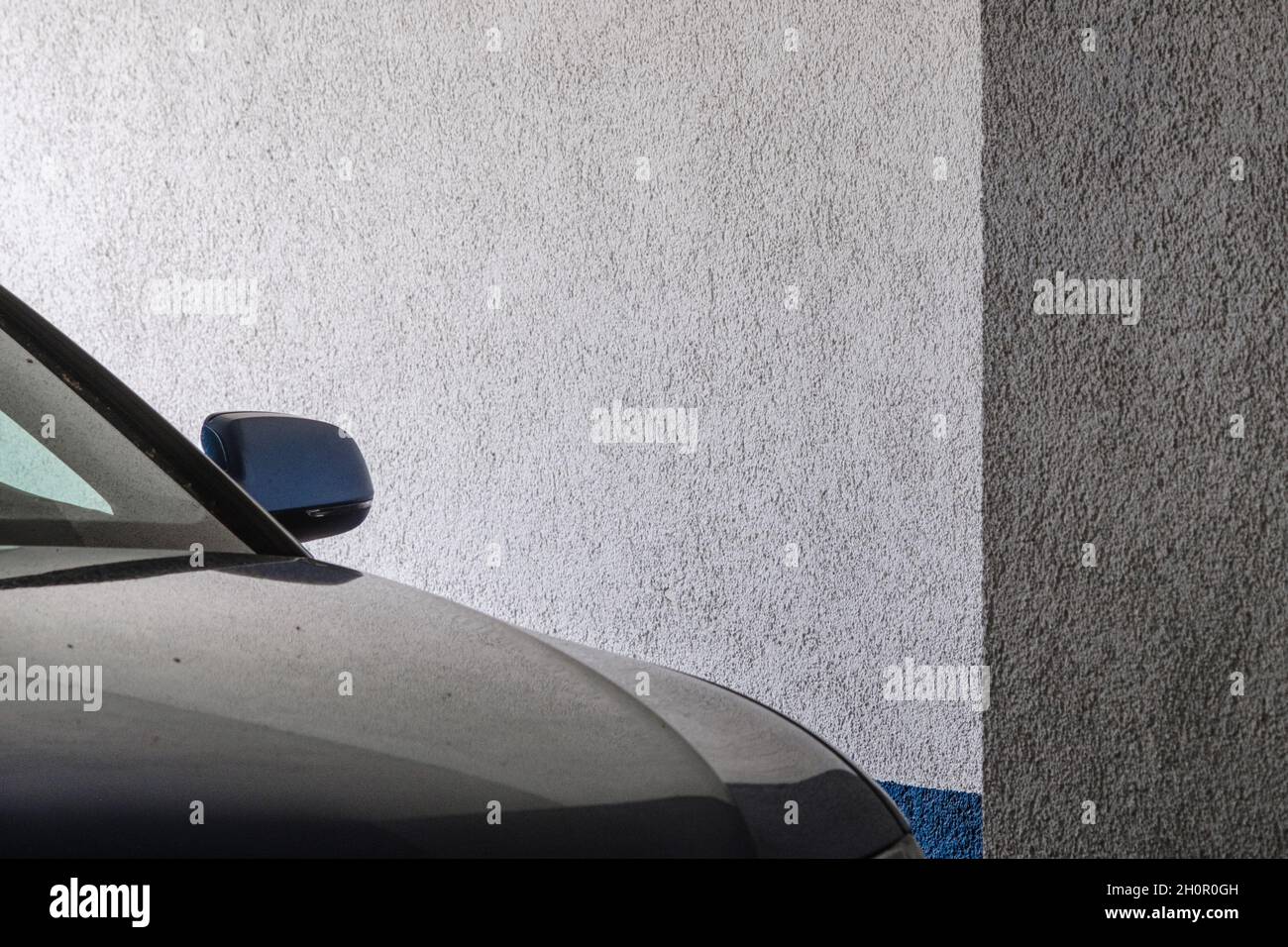 Shot of a front glass window of a black car and the side left mirror ...