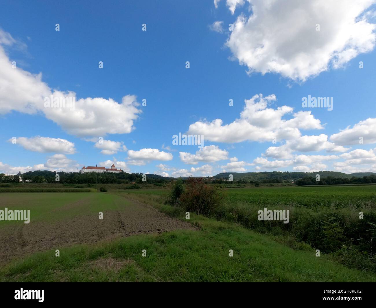 Beautiful landscape with a big building among trees under the cloudy ...