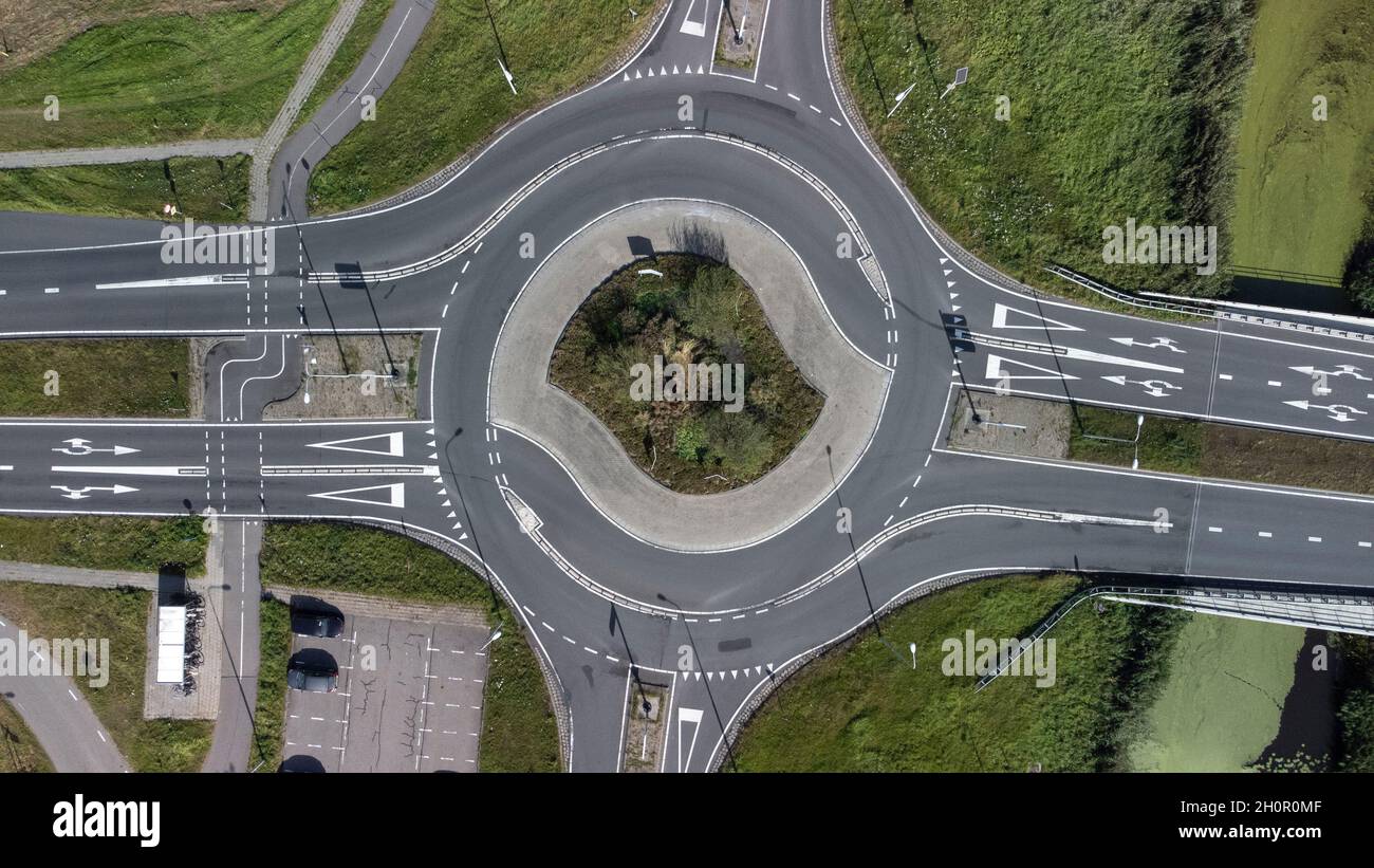 Top down aerial view of a traffic roundabout on a main road in an urban ...