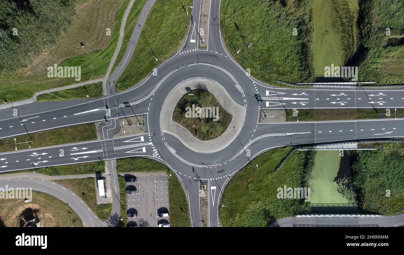 Top down aerial view of a traffic roundabout on a main road in an urban ...