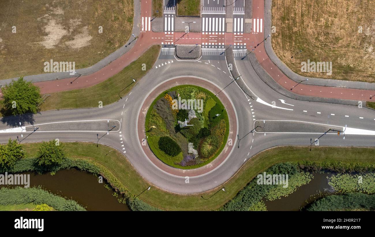 Top down aerial drone view of a small traffic roundabout on a quiet ...