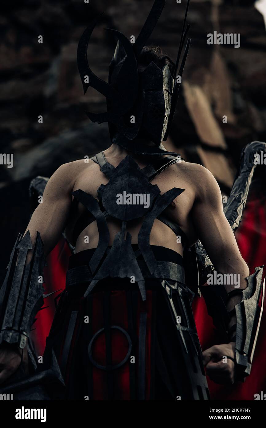 Man in image of daemon of death with wings behind his back stands with ...