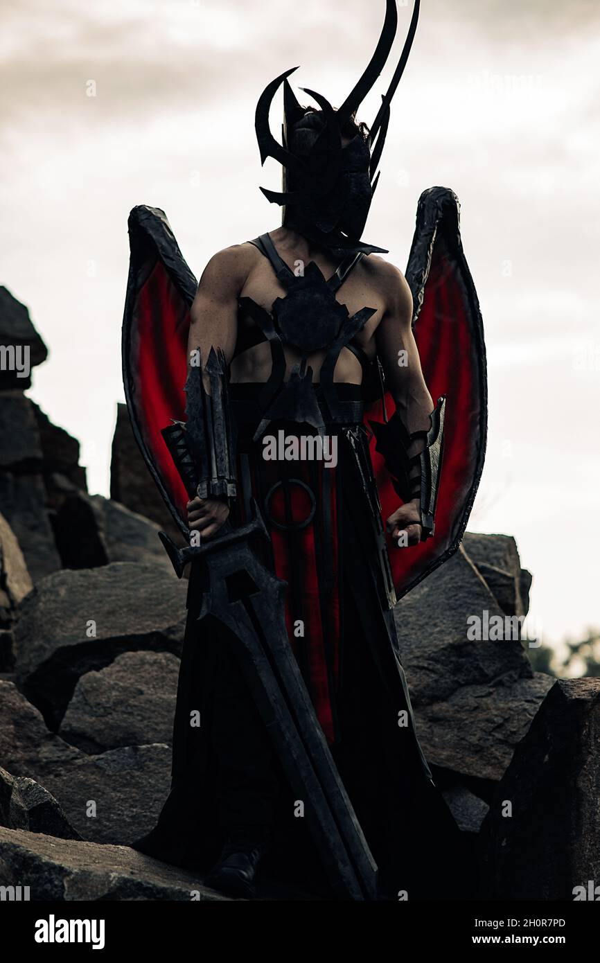 Man in image of daemon of death with wings behind his back stands with ...