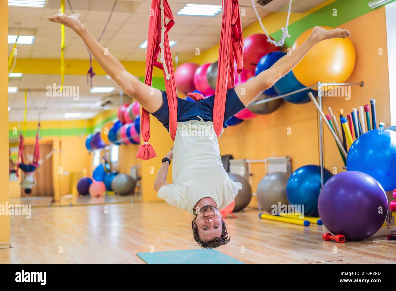 Young man practicing aerial yoga in gym. Lifestyle Stock Photo - Alamy