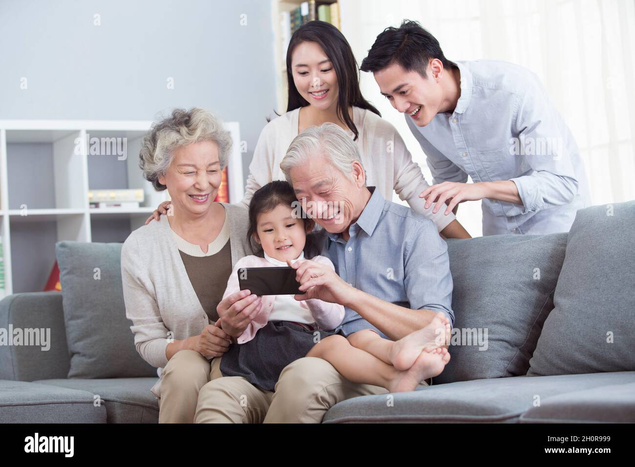 A family of five using a mobile phone Stock Photo - Alamy