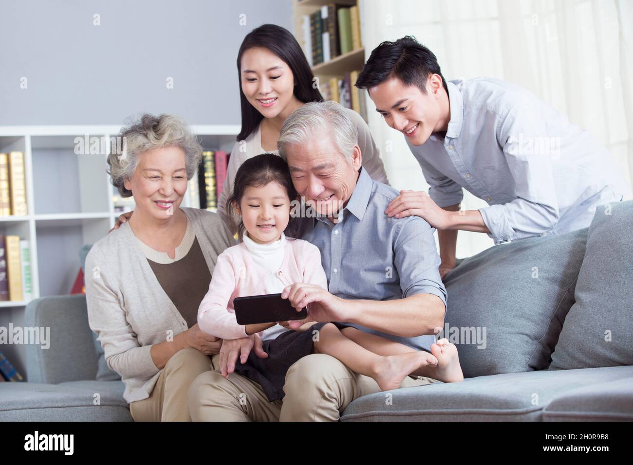 A family of five using a mobile phone Stock Photo - Alamy
