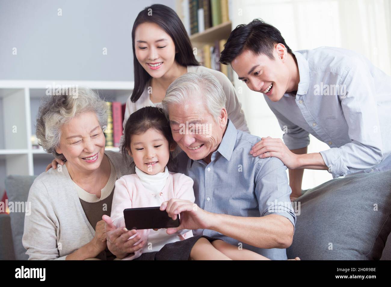 A family of five using a mobile phone Stock Photo - Alamy