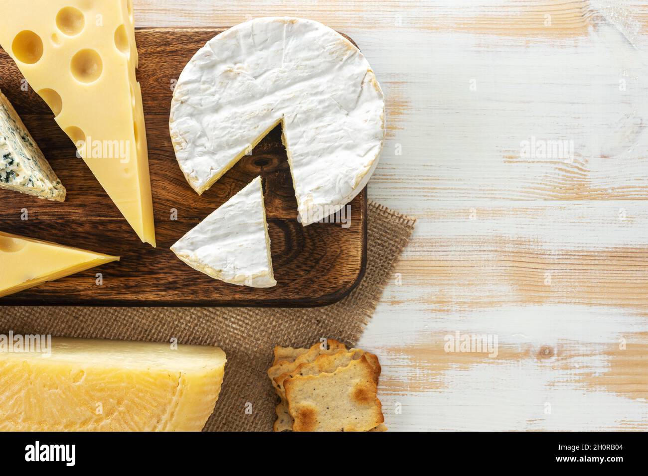 Assortment of different cheese types on white wooden table. Cheese ...