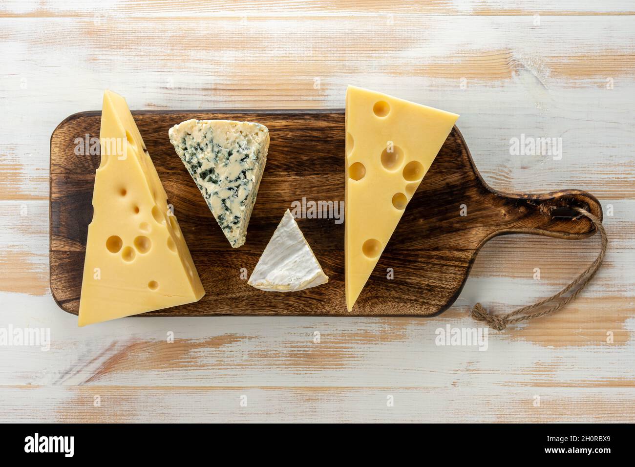 Assortment of different cheese types on white wooden table. Cheese ...