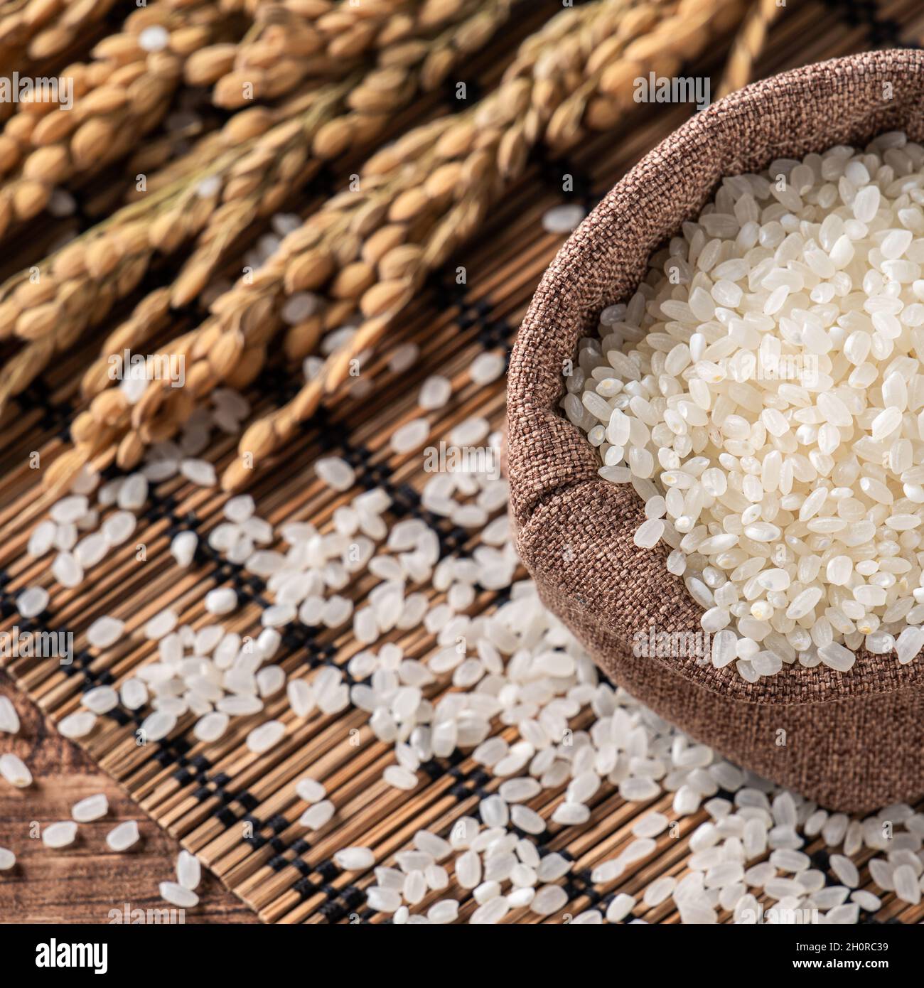 Raw white polished milled edible rice on wooden table background in a ...