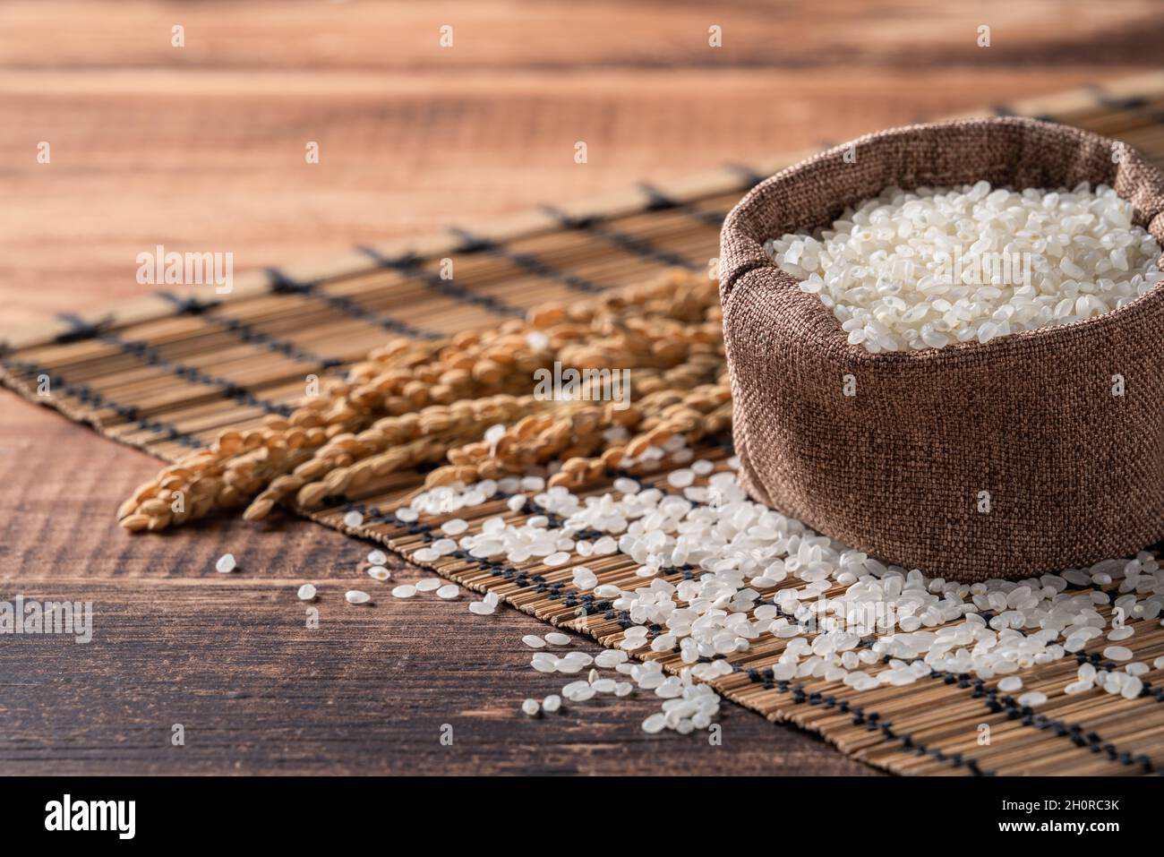 Raw white polished milled edible rice on wooden table background in a ...