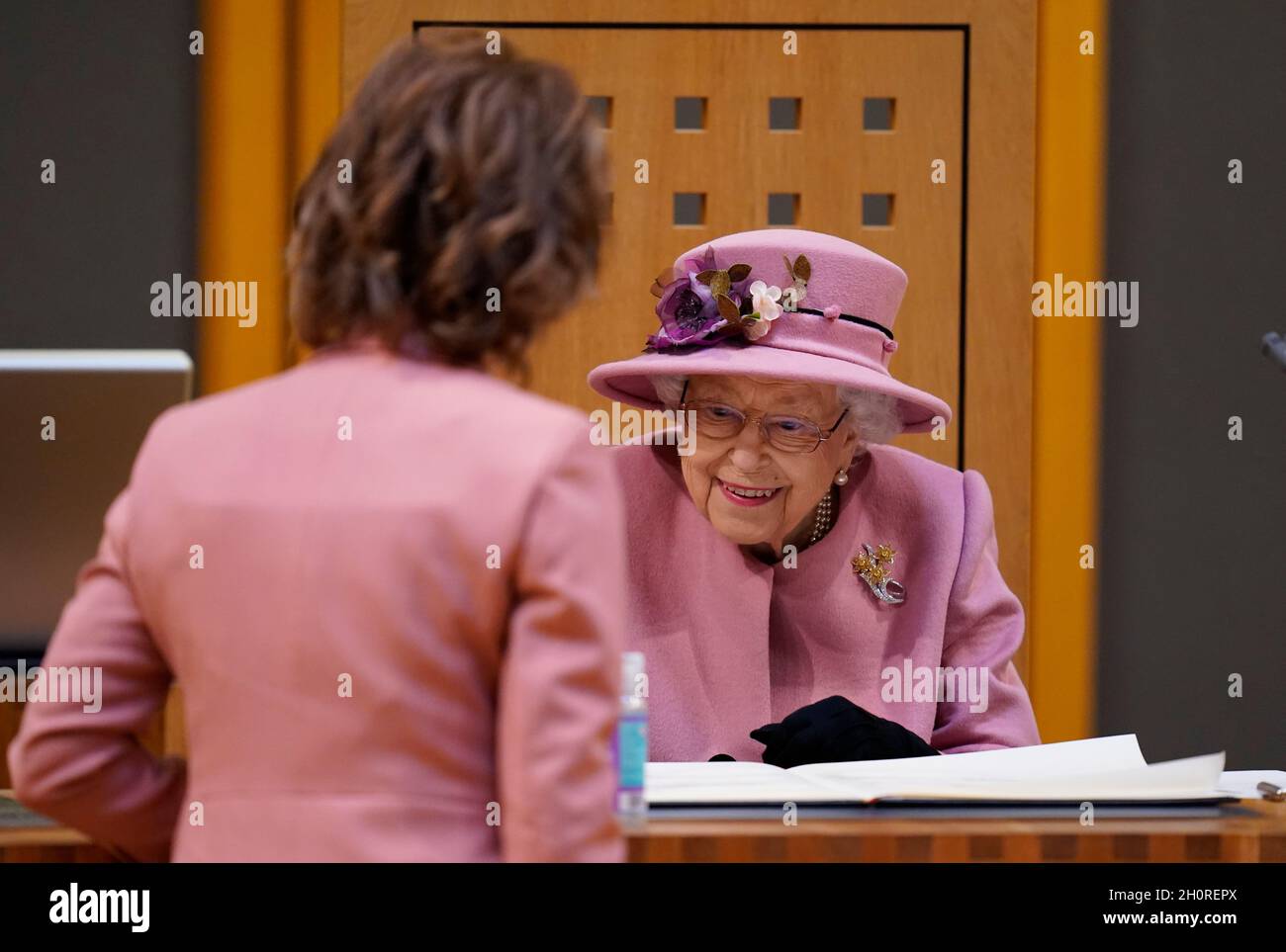 Queen Elizabeth II signs a commemorative parchment in the Senedd inside ...