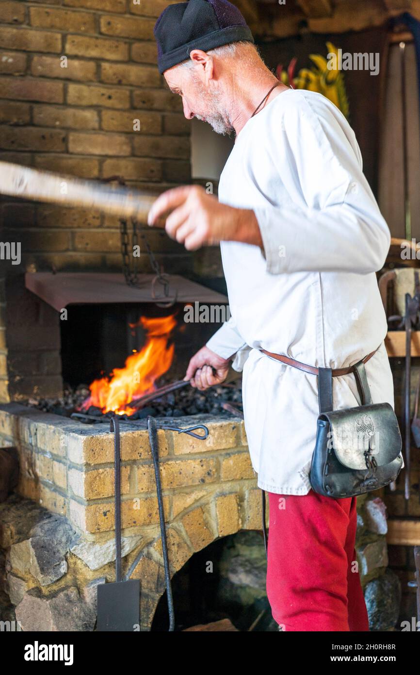Medieval reenactment with a senior man in medieval costume, pumping the ...