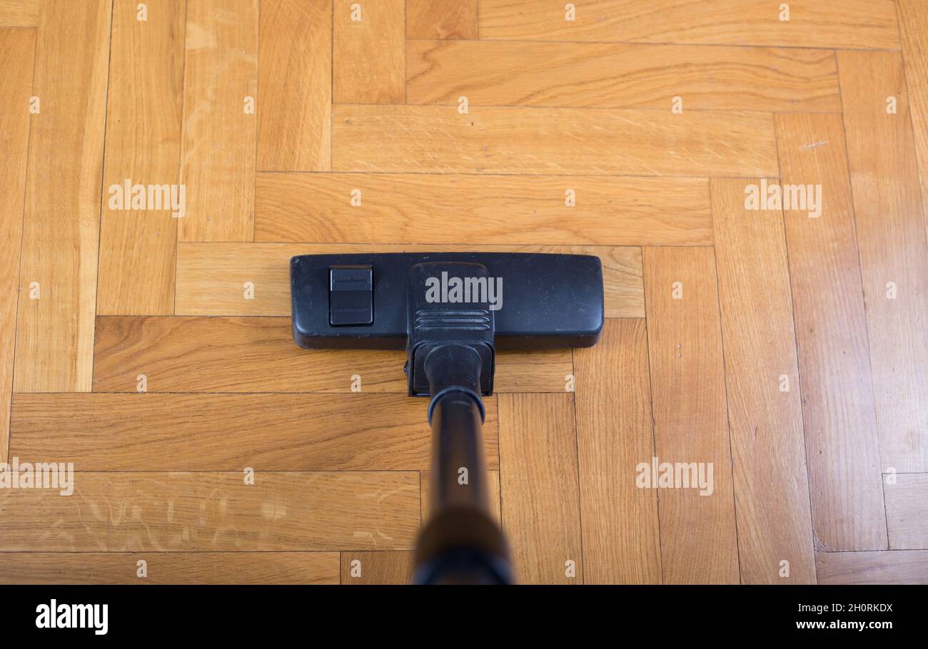 Top view of head of vacuum cleaner on parquet floor. Housekeeping ...