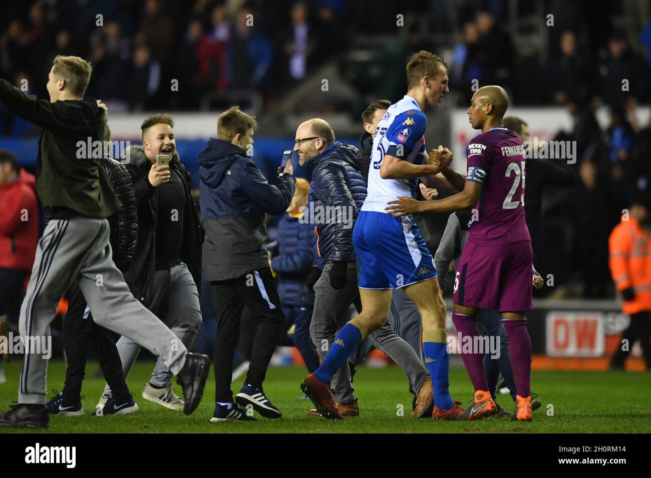 Wigan fans invade the pitch at the final whistle Stock Photo - Alamy