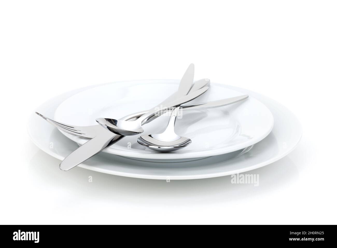 Silverware over plates. Isolated on white background. Set of fork ...