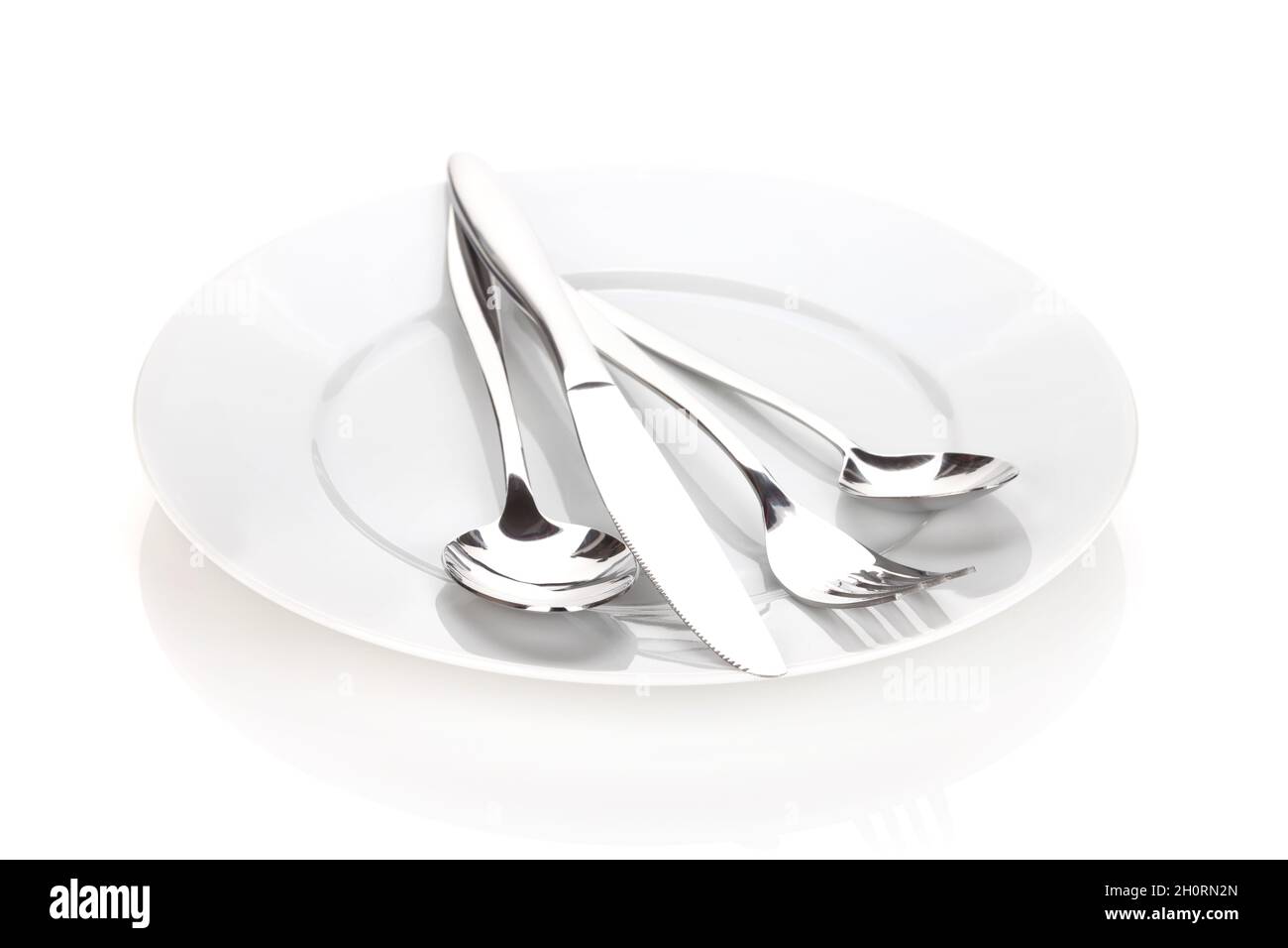 Silverware over plates. Isolated on white background. Set of fork ...