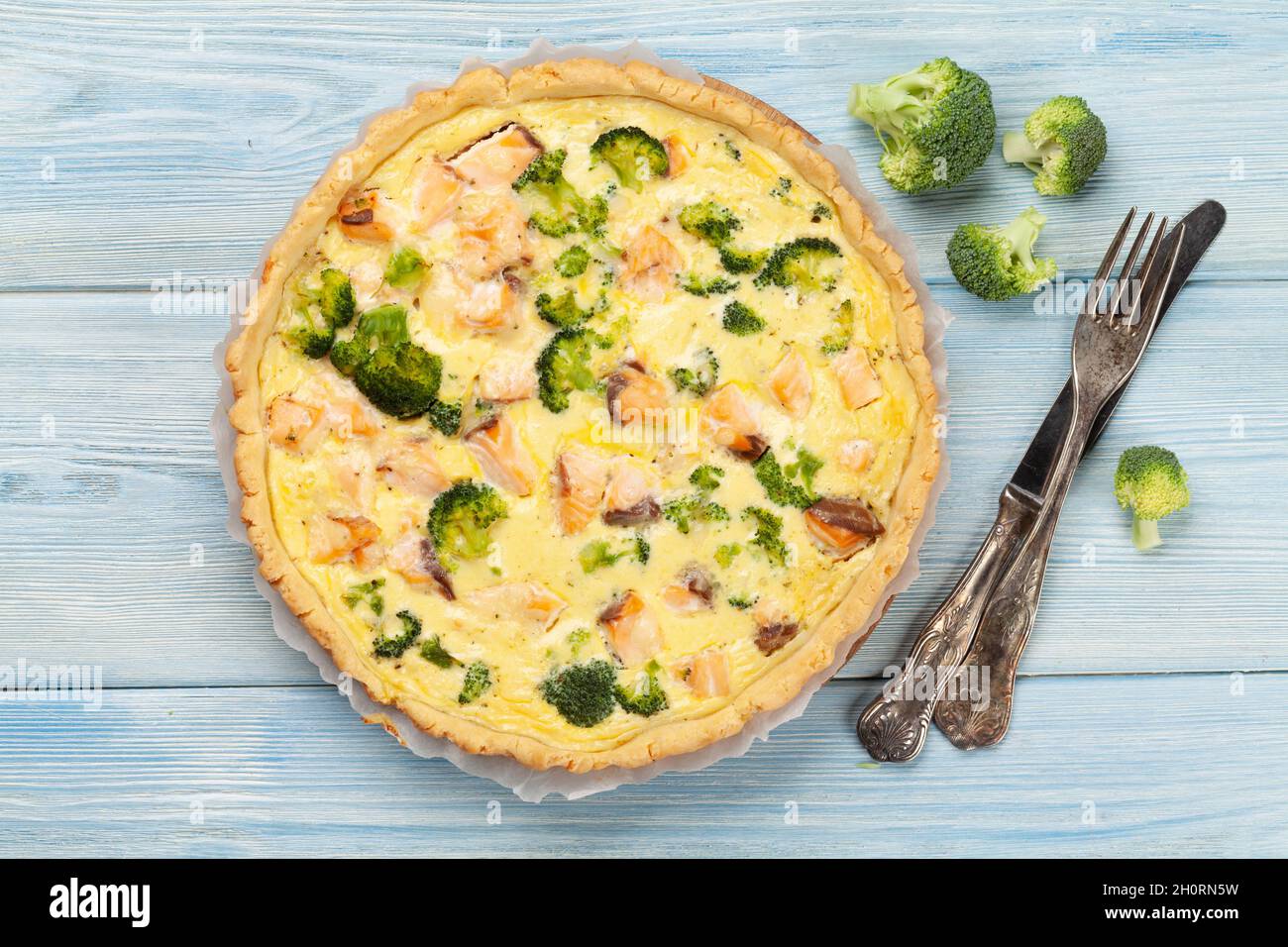 Homemade fish pie. Open faced salmon and broccoli pie on kitchen table ...