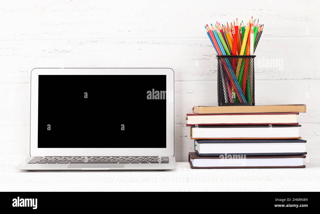 Home office with laptop, notepads and colorful pencils. With copy space ...