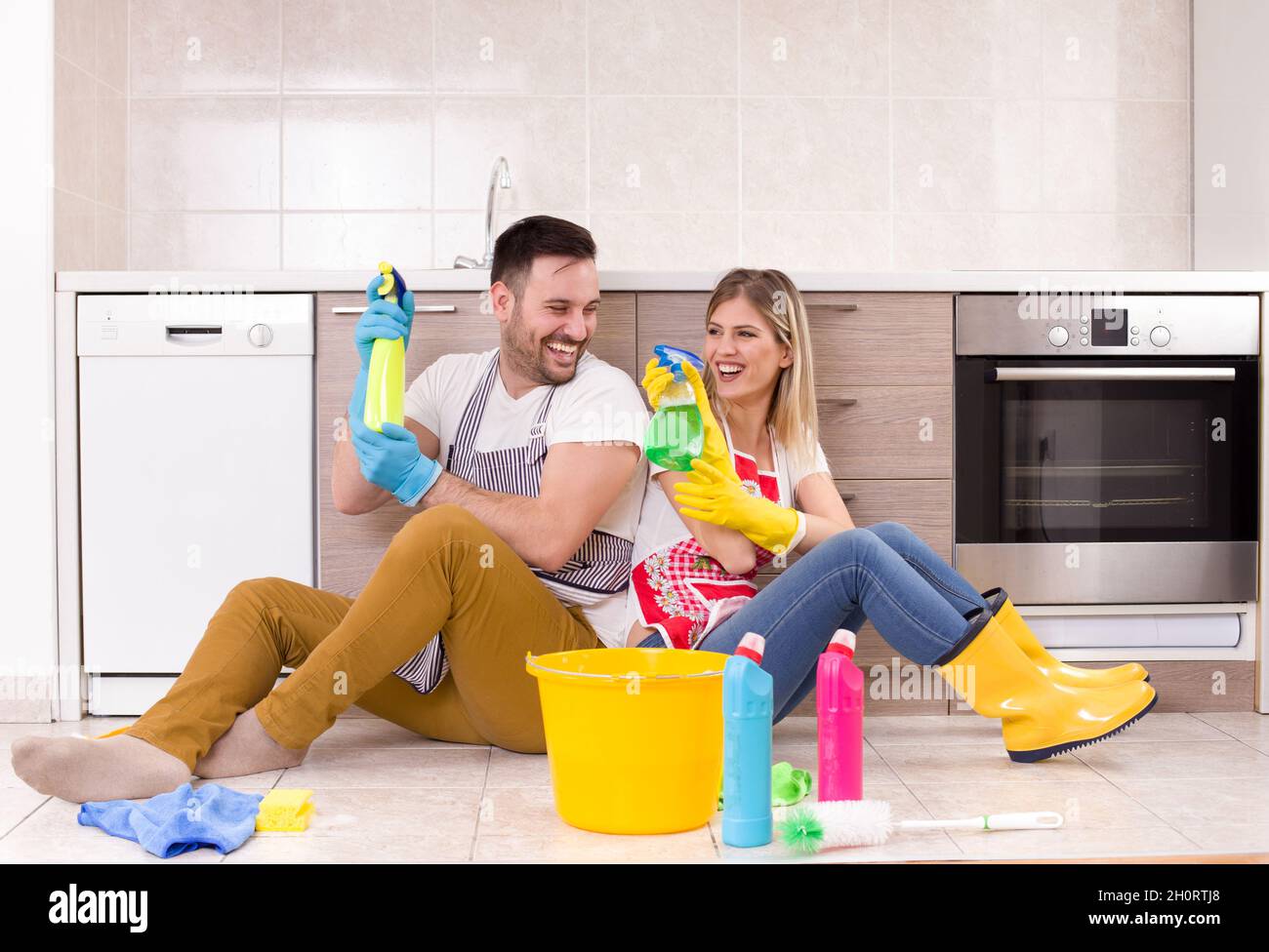 Young couple having fun on kitchen floor after finishing chores Stock ...