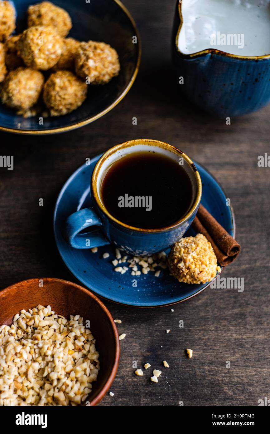 Healthy home made candy balls coated in chopped nuts with a cup of ...