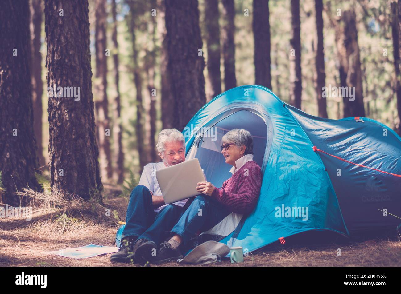 Active senior people enjoy tent camping outdoor in free forest ...