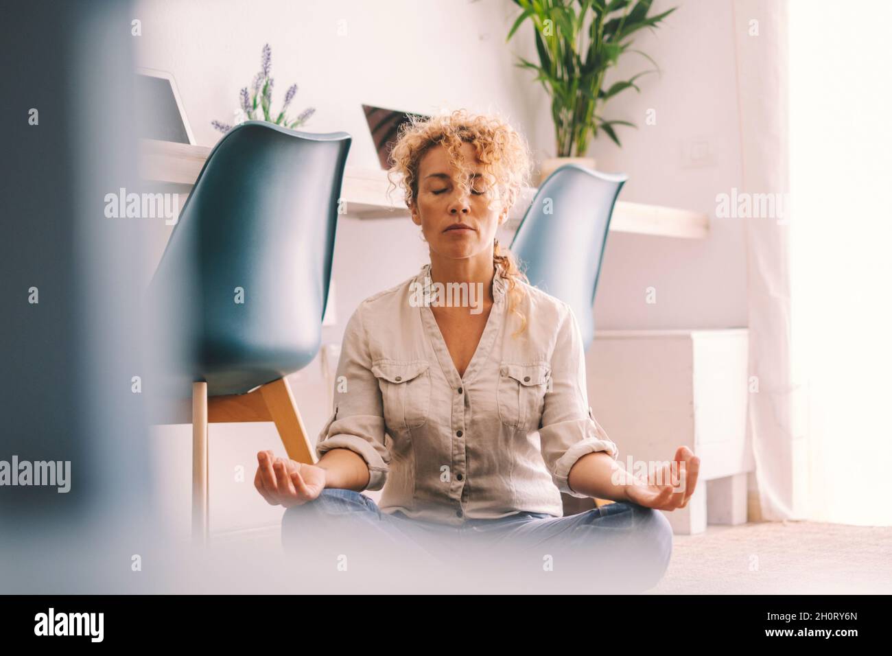 Woman do loto position at home to relax and wellbeing. Indoor relaxed ...