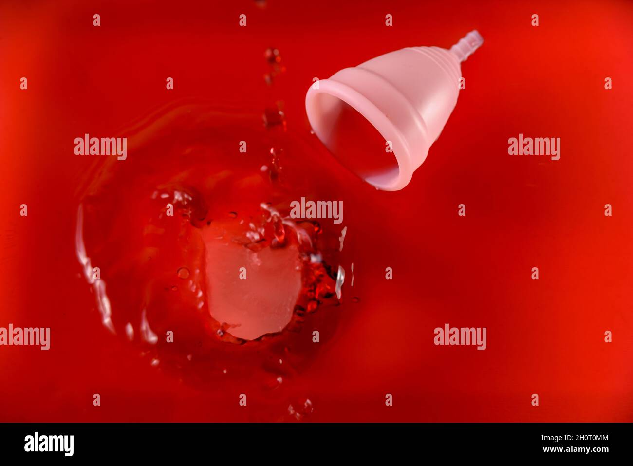 Pink reusable menstrual cup on red blood liquid background Stock Photo ...